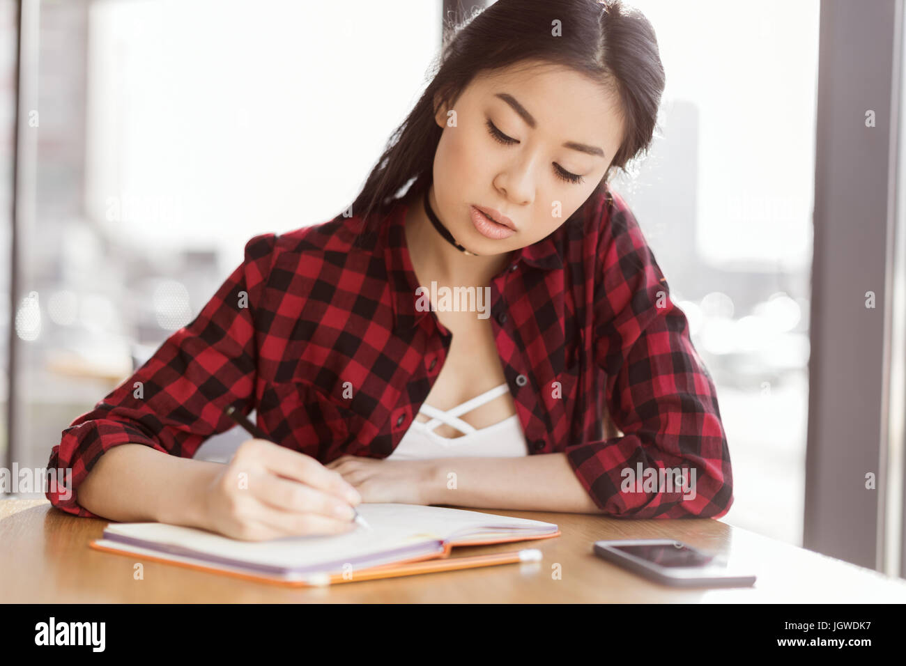 attractive asian student writing in diary and sitting in cafe Stock ...