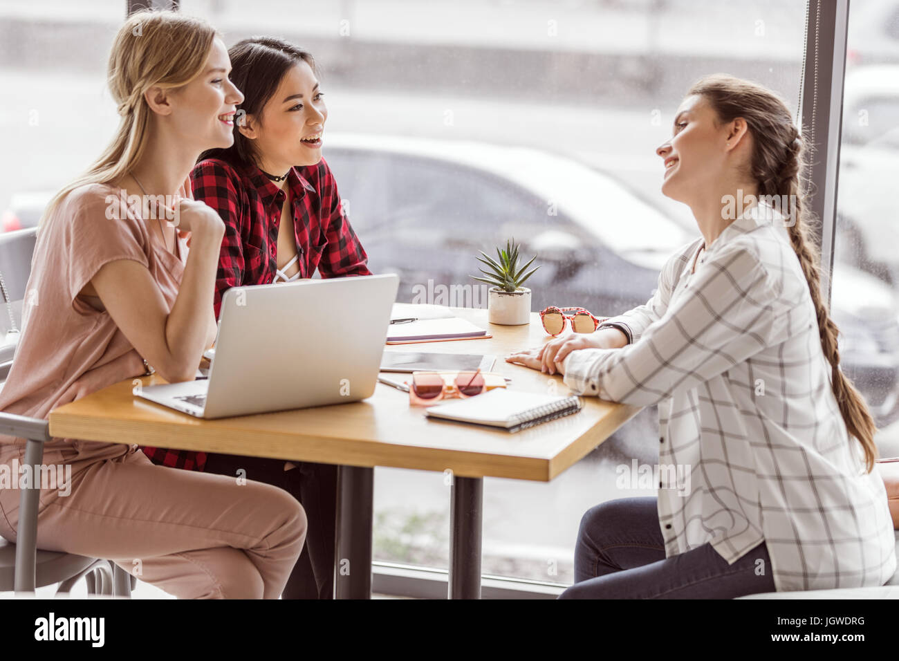 group of stylish friends spending time together in cafe Stock Photo - Alamy
