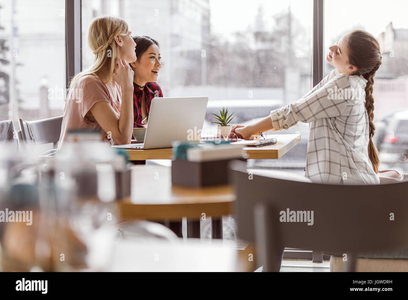 group of stylish friends spending time together in cafe Stock Photo - Alamy