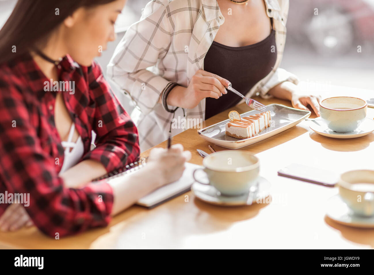 young girls eating cake and drinking coffee at cafe, coffee break Stock ...