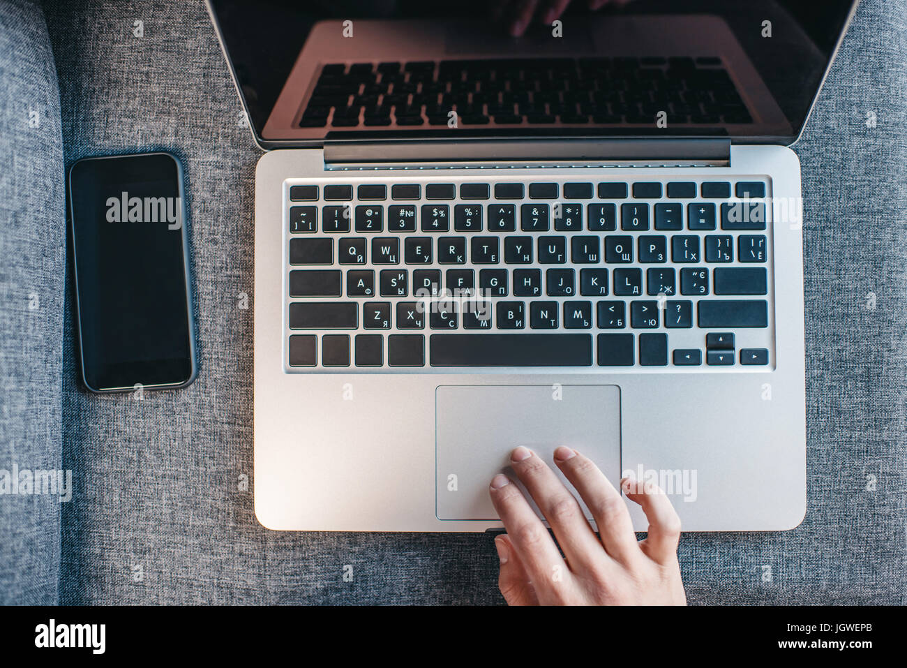 Top view of human hand using touchpad on laptop. Laptop and smartphone ...