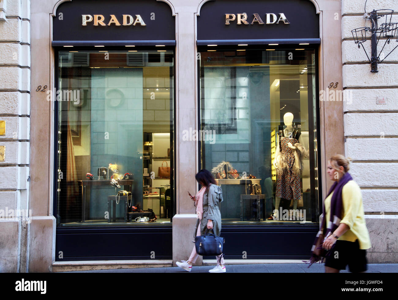 Pedestrians walk past of the shop window of Prada store in Rome Italy ...
