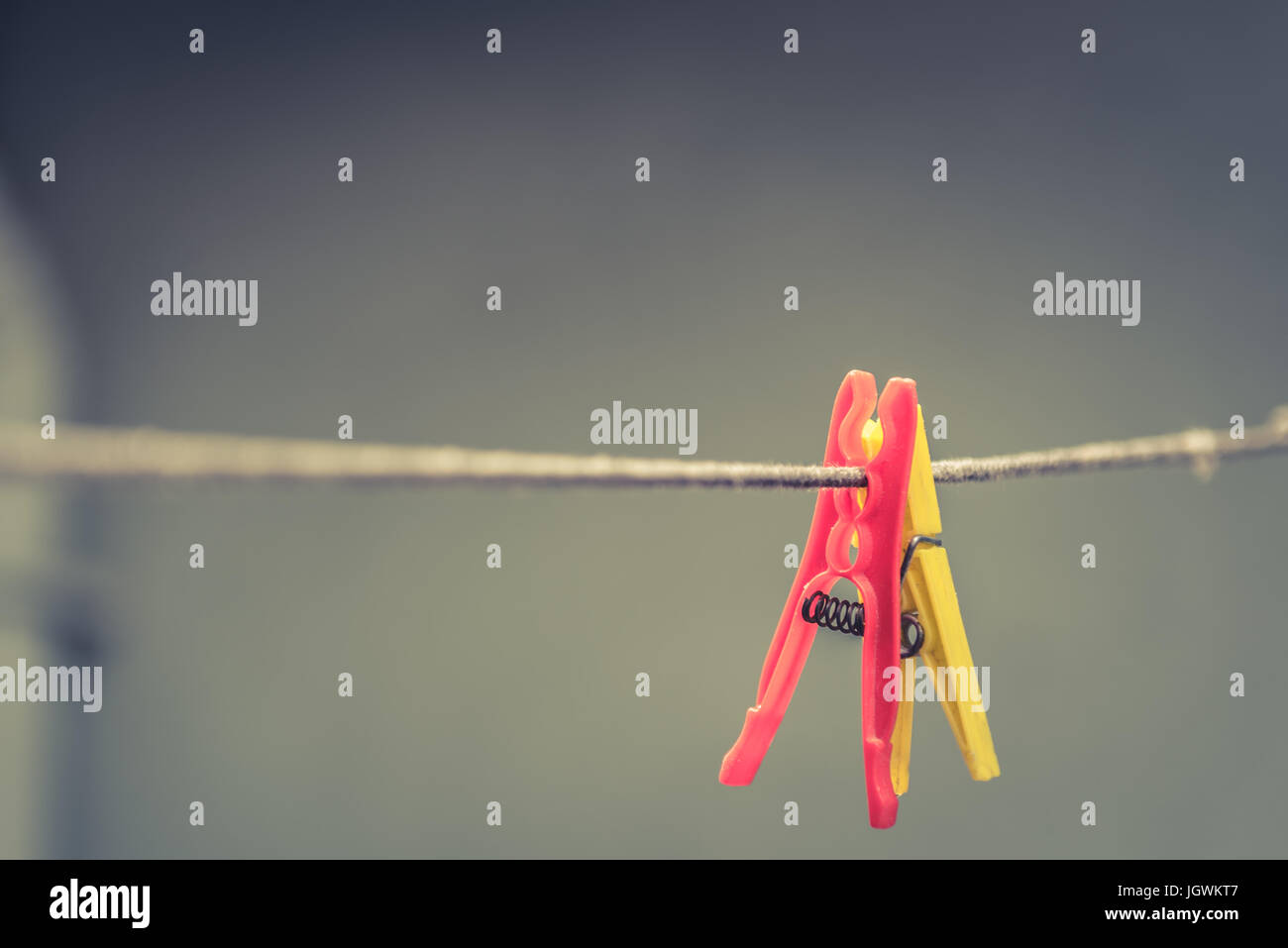 Vintage view of Clothes peg pinned to a bench with dark wall in a ...