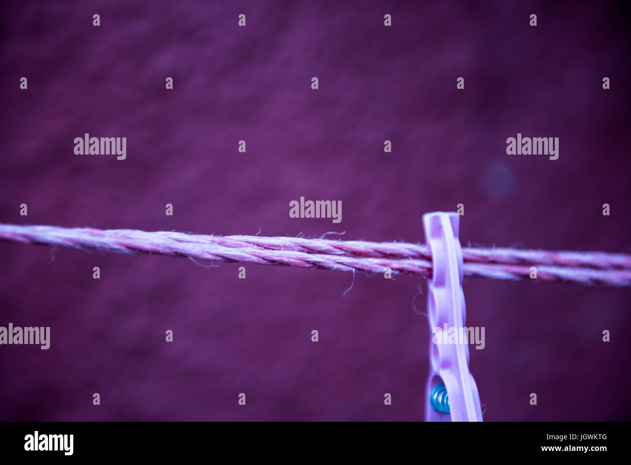 Vintage view of purple Clothes pegs pinned to a bench with purple wall ...