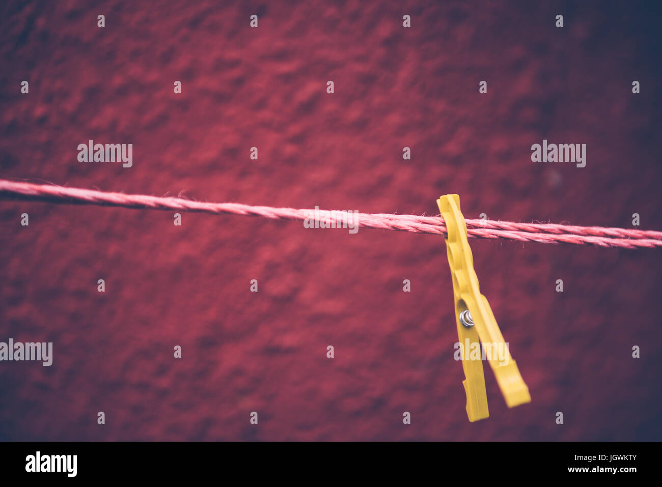Vintage view of yellow Clothes pegs pinned to a bench with dark red ...