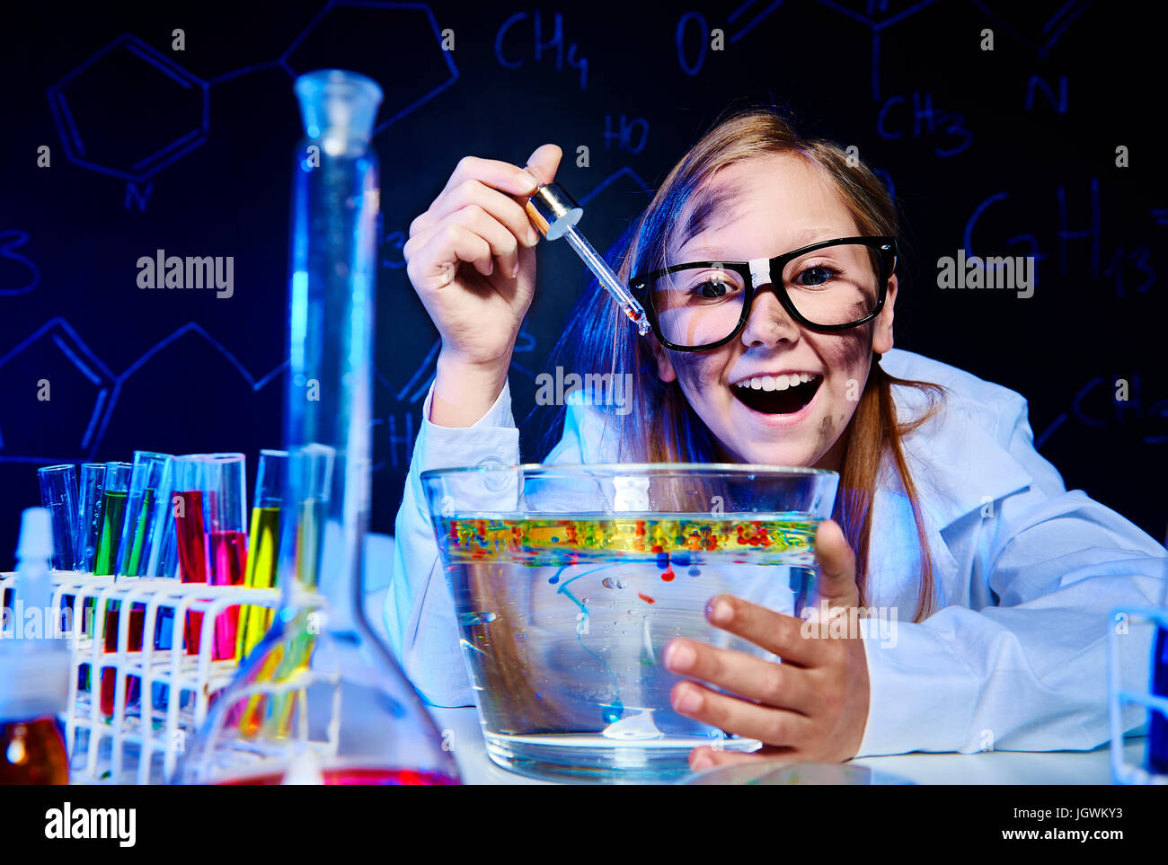 Smiling little girl making a experiment Stock Photo - Alamy