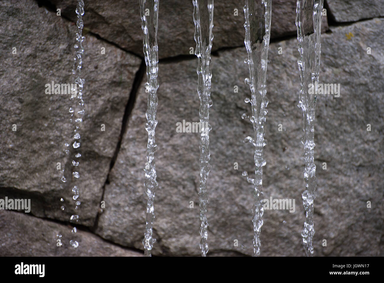 Streaming water on rocks background Stock Photo - Alamy