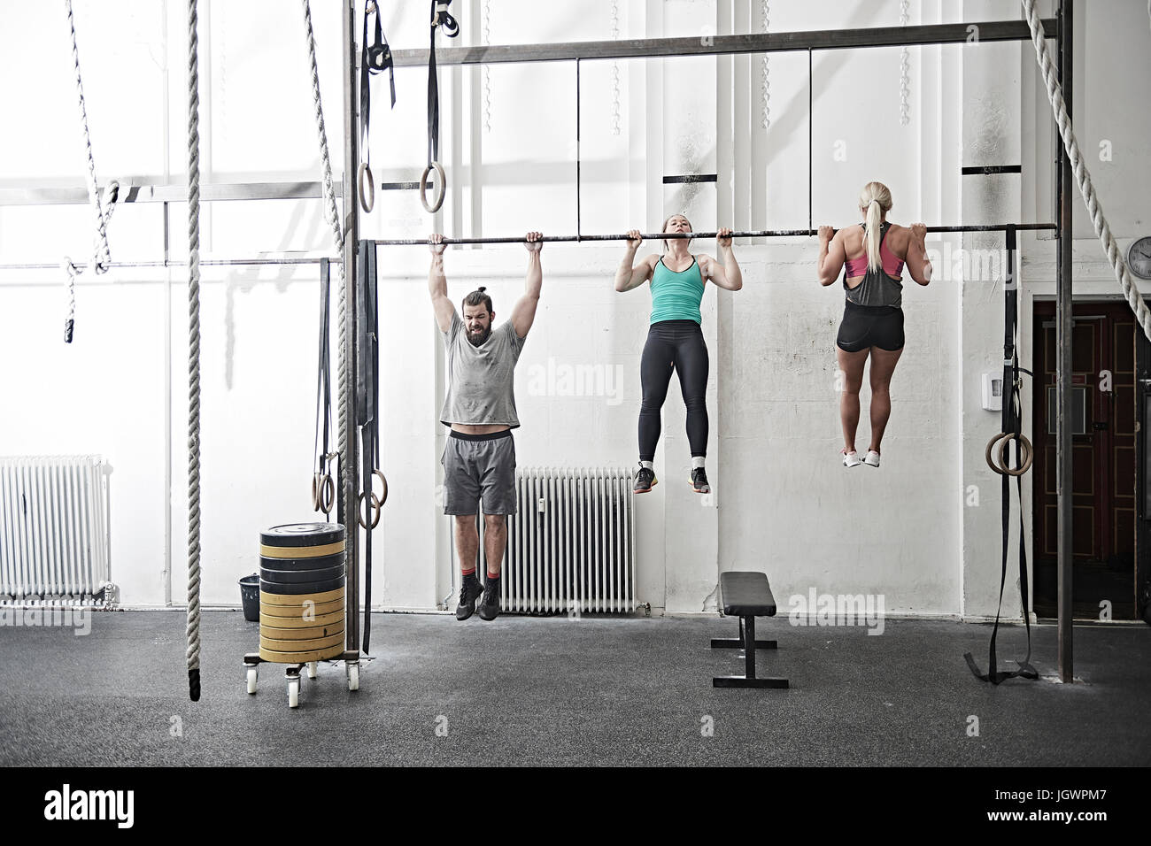 Friends doing chin-up in cross training gym Stock Photo - Alamy