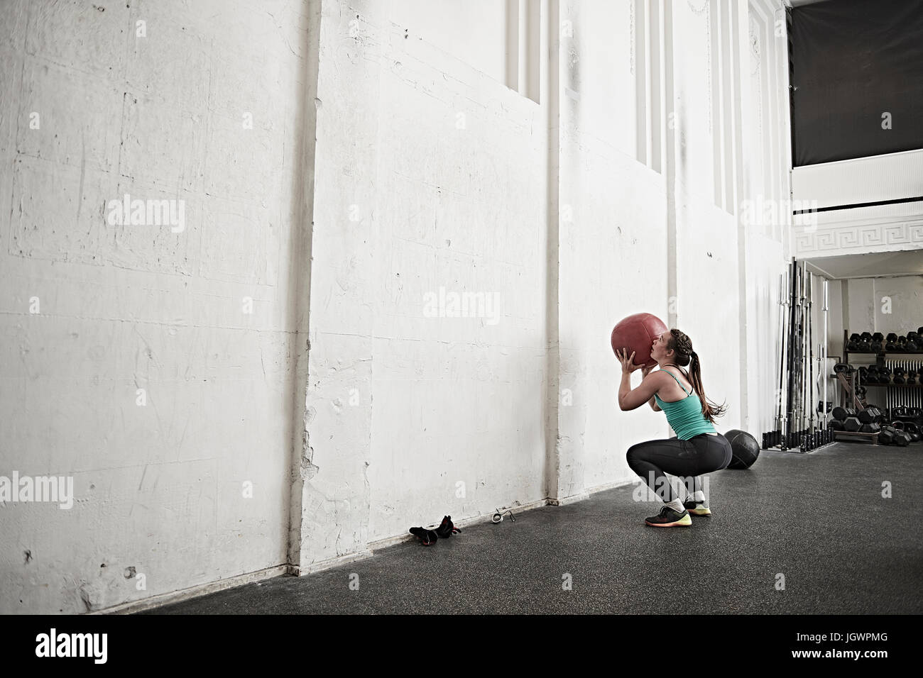 Woman throwing fitness ball against wall in cross training gym Stock ...