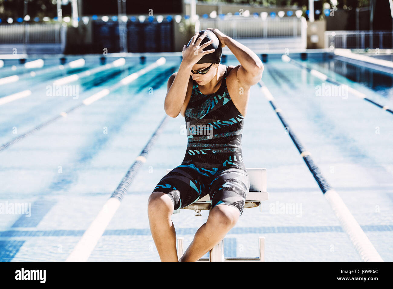 Swimmer sitting at end of pool Stock Photo - Alamy
