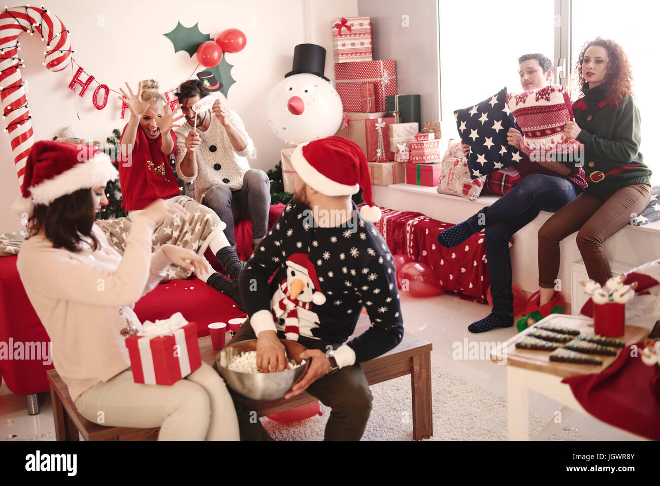 Young women and men throwing popcorn at christmas party Stock Photo - Alamy
