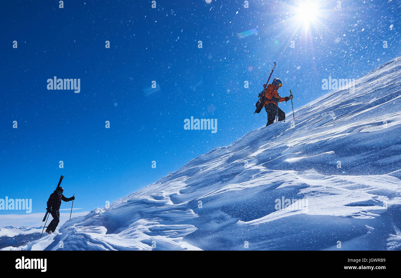 Two male skiers trudging up snow covered mountain, Aspen, Colorado, USA ...