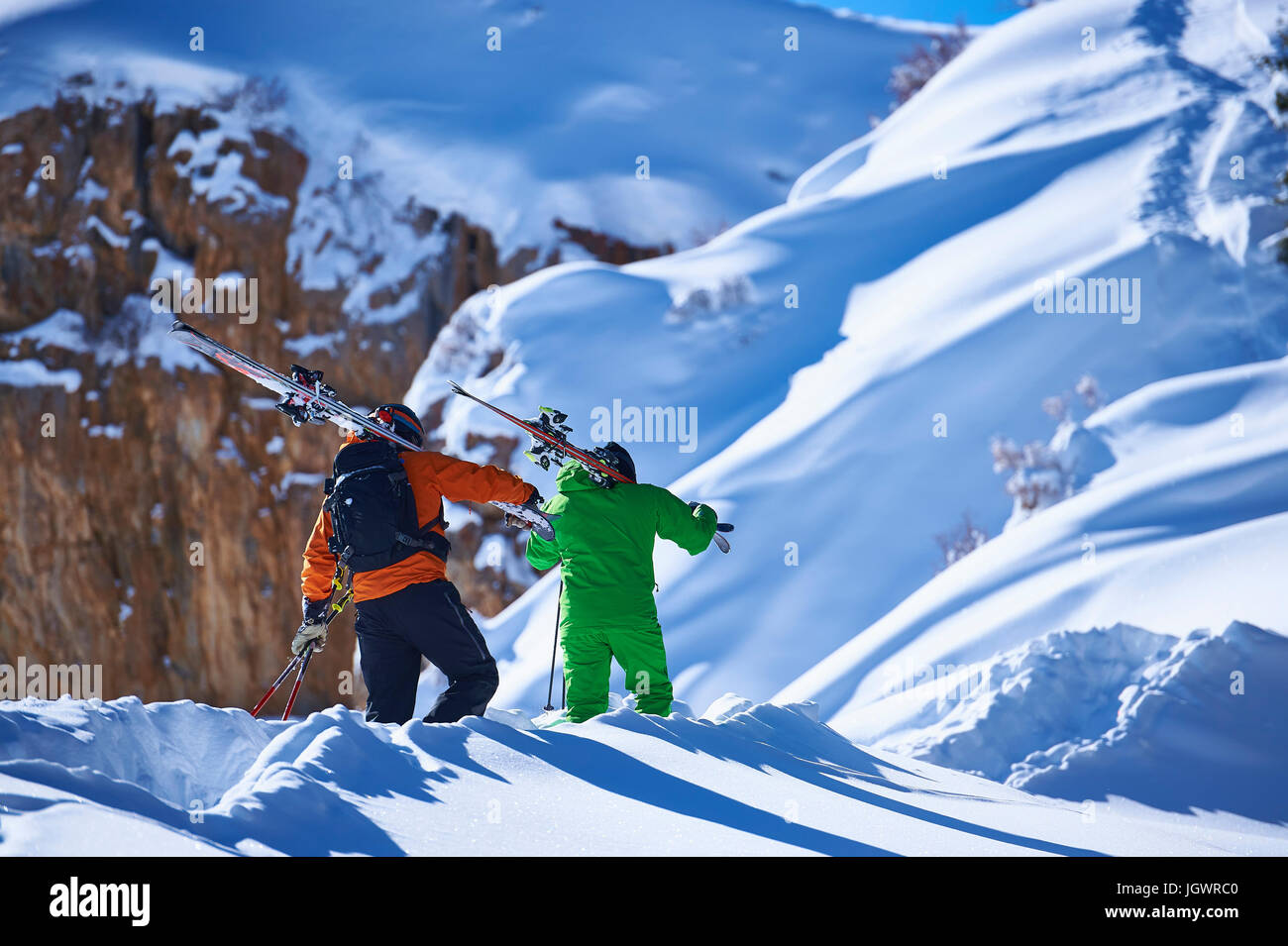 Two male skiers trudging up deep snow covered mountain, Aspen, Colorado ...