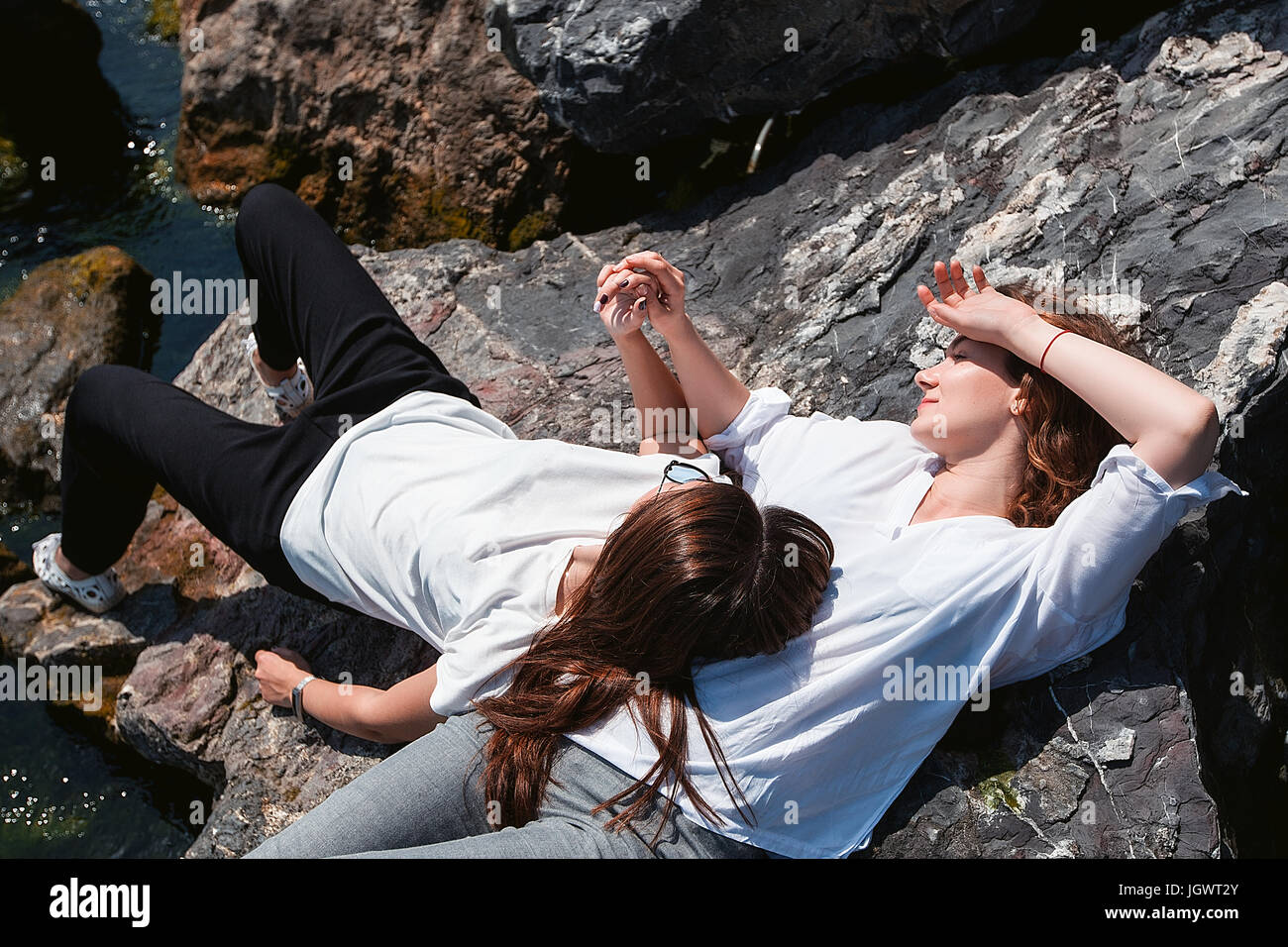 Best friends relaxing on rocks Stock Photo - Alamy