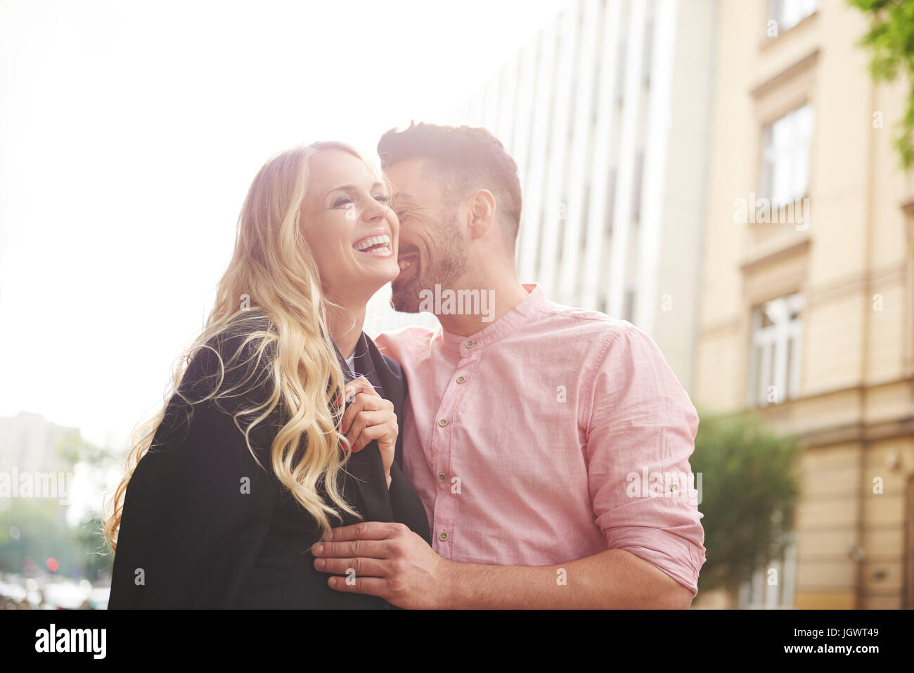 Man in street sharing suit jacket with woman Stock Photo - Alamy