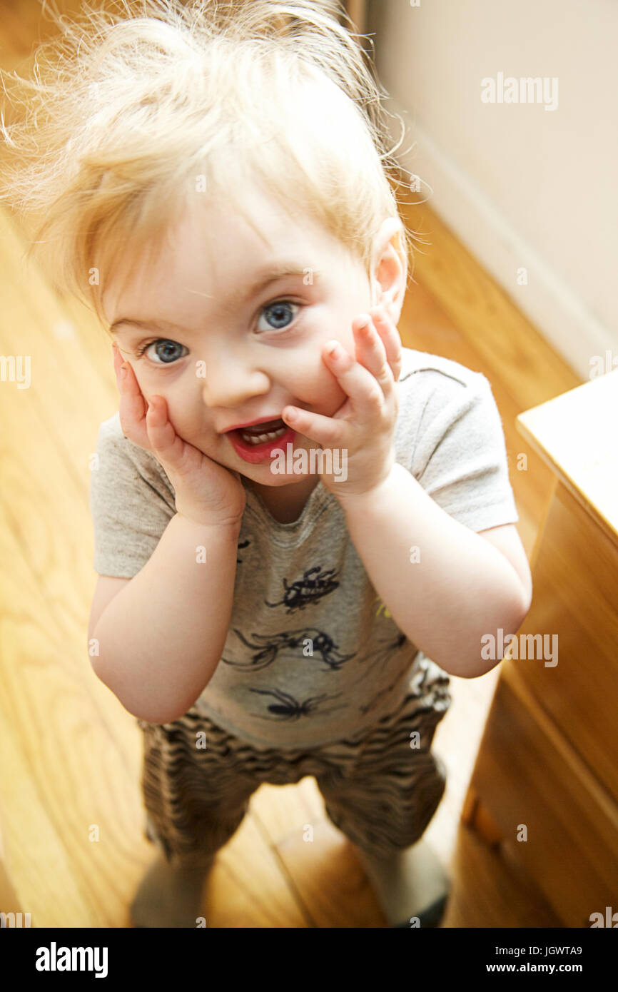 Portrait of cute male toddler with hands on cheeks Stock Photo - Alamy