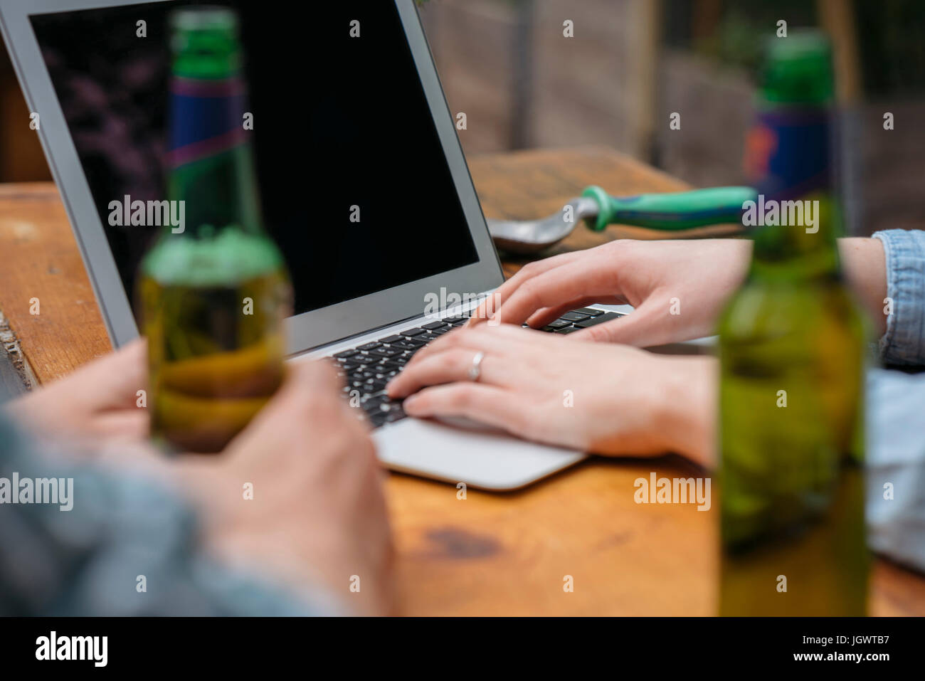 Cropped view of couple drinking beer using laptop Stock Photo - Alamy