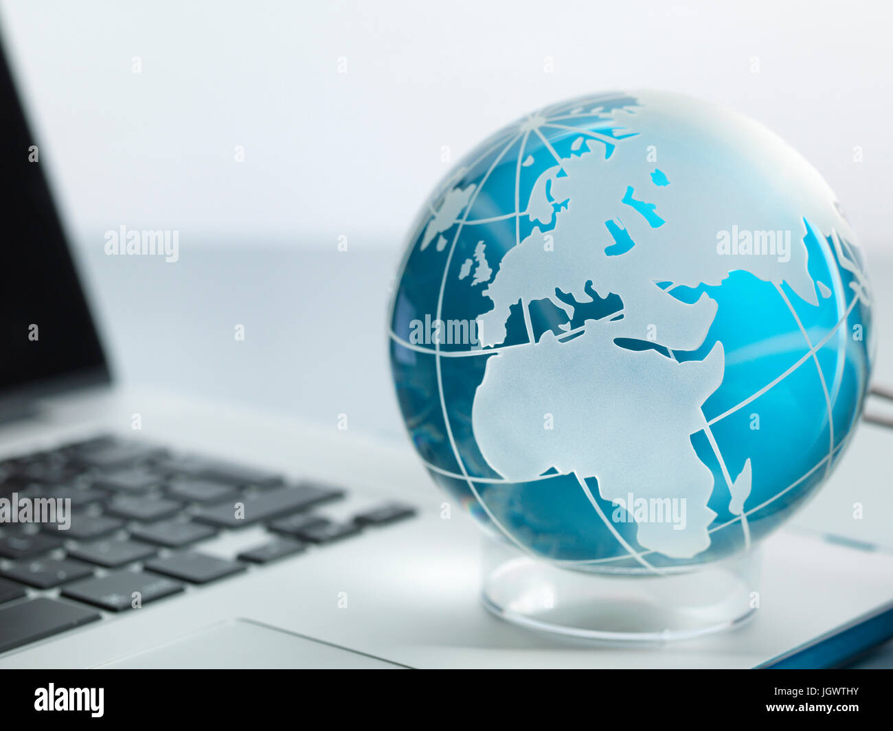 Globe and laptop on desk Stock Photo - Alamy