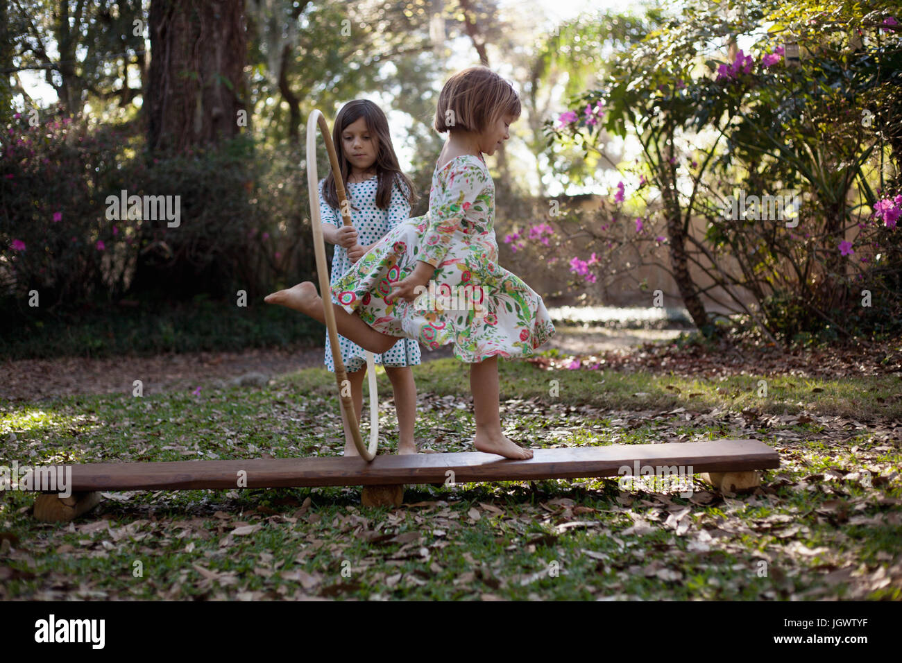 Girl holding plastic hoop, sister running through Stock Photo - Alamy
