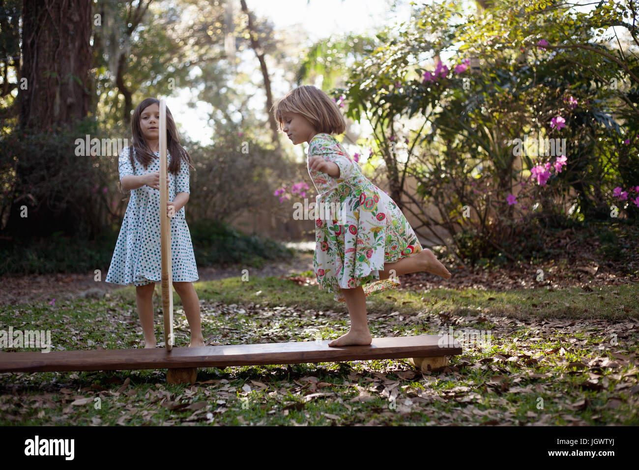 Girl holding plastic hoops with sister running through Stock Photo - Alamy