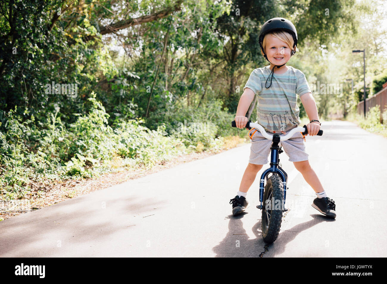 Portrait of young boy riding bicycle outdoors Stock Photo - Alamy