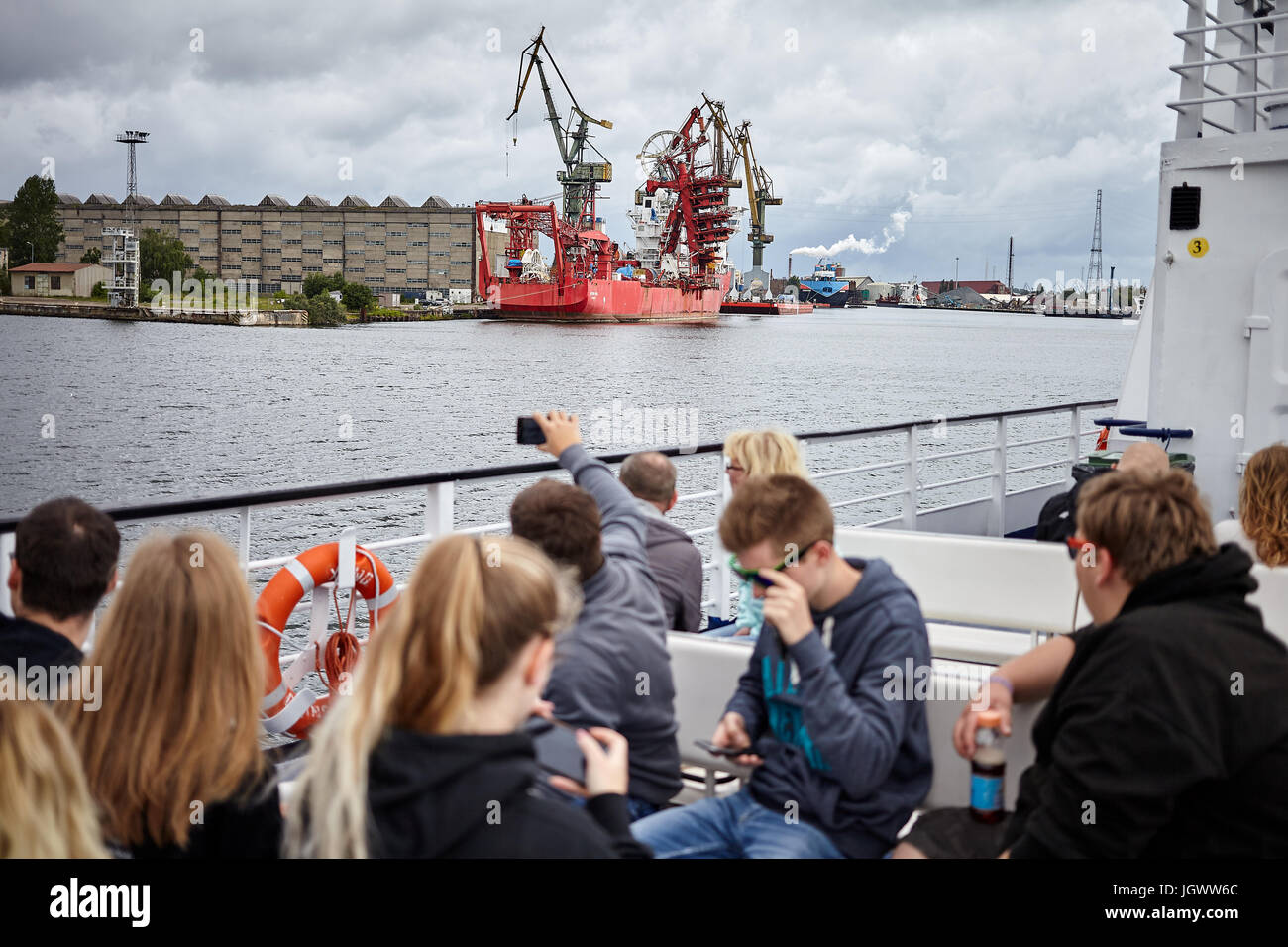 Tourists on the vessel sailing through the shipyard area in Gdansk ...