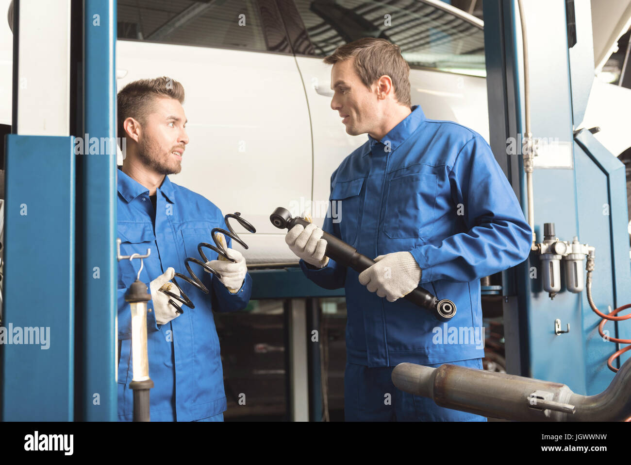 Would you help me. Skillful smart diligent man repairing an auto in the ...