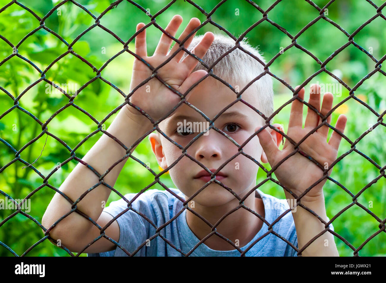 Boy behind wire fence hi-res stock photography and images - Alamy