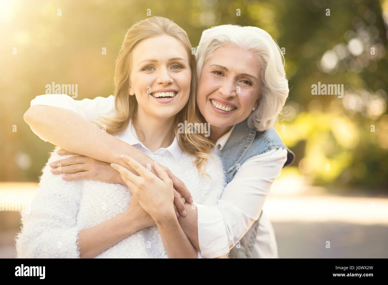 Sharing hugs. Smiling happy young woman walking in the park while ...