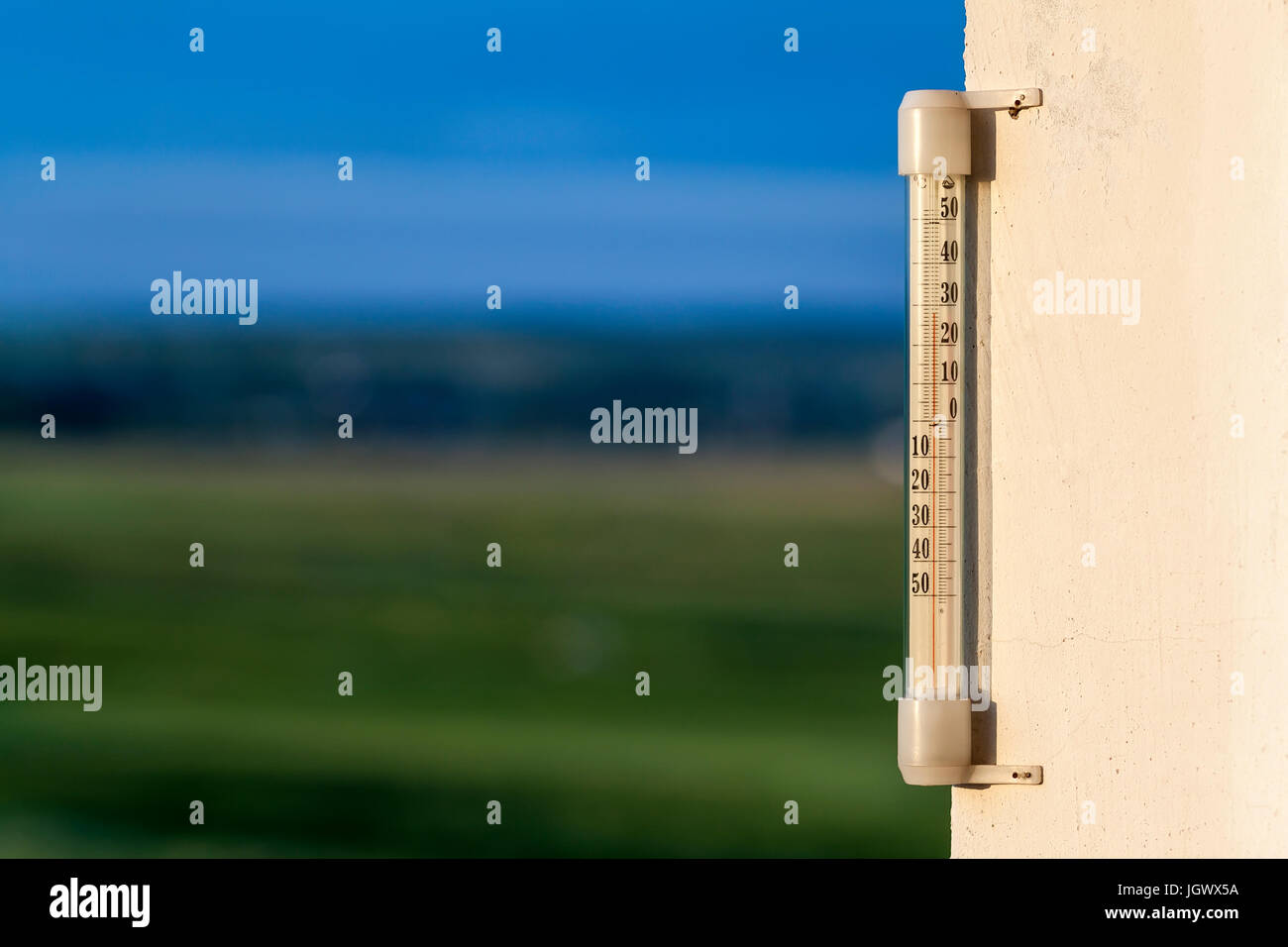Thermometer celsius showing warm temperature on blurred green ...