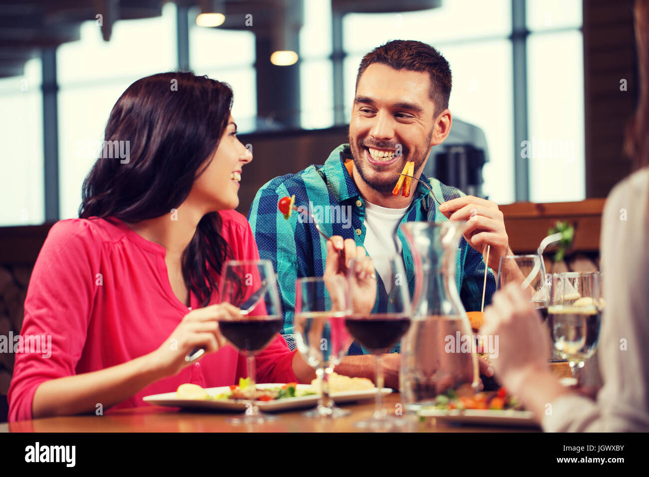 happy couple with friends eating at restaurant Stock Photo - Alamy
