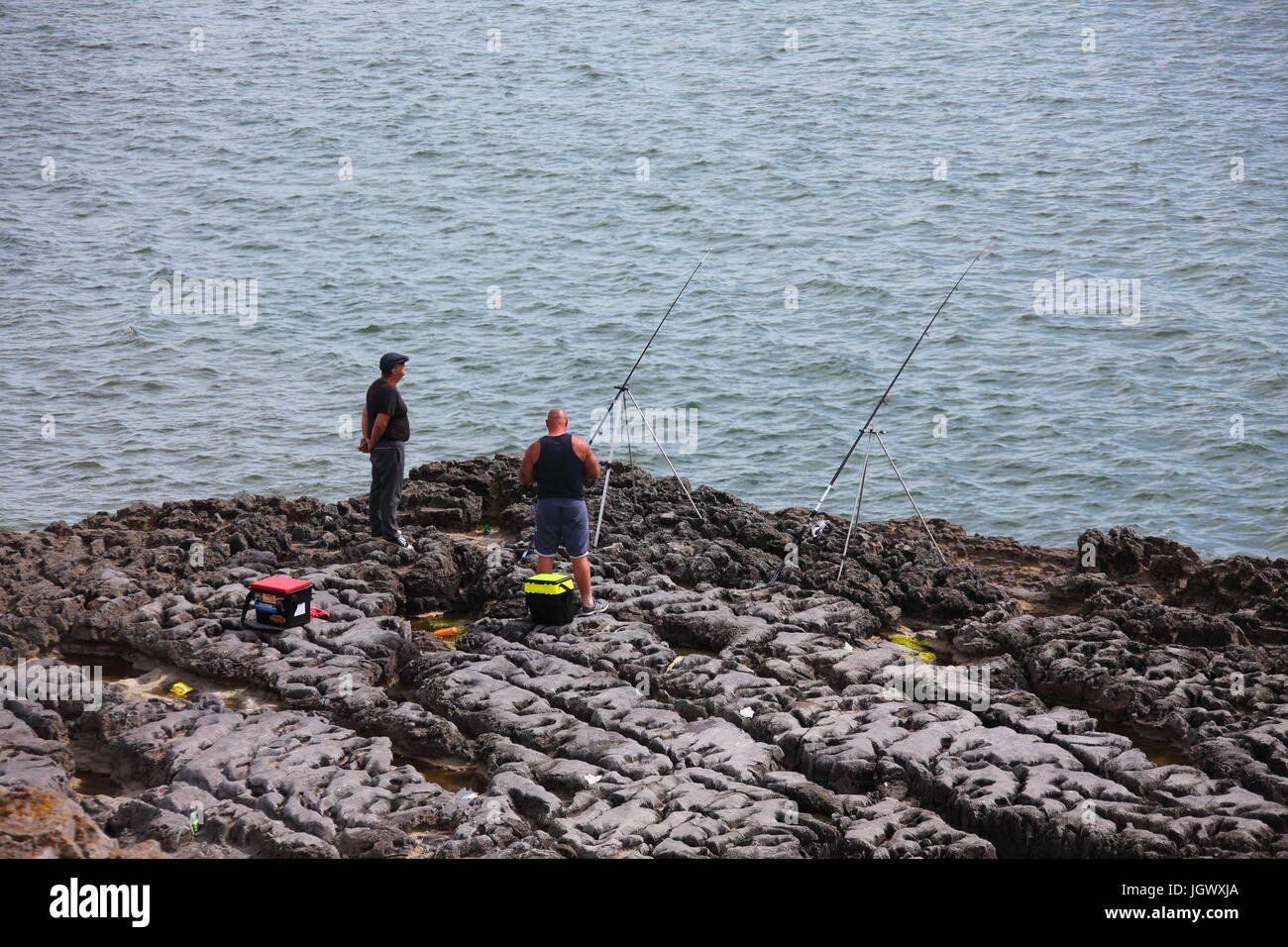 Two fishermen looking at there rods and waiting for that elusive bite ...