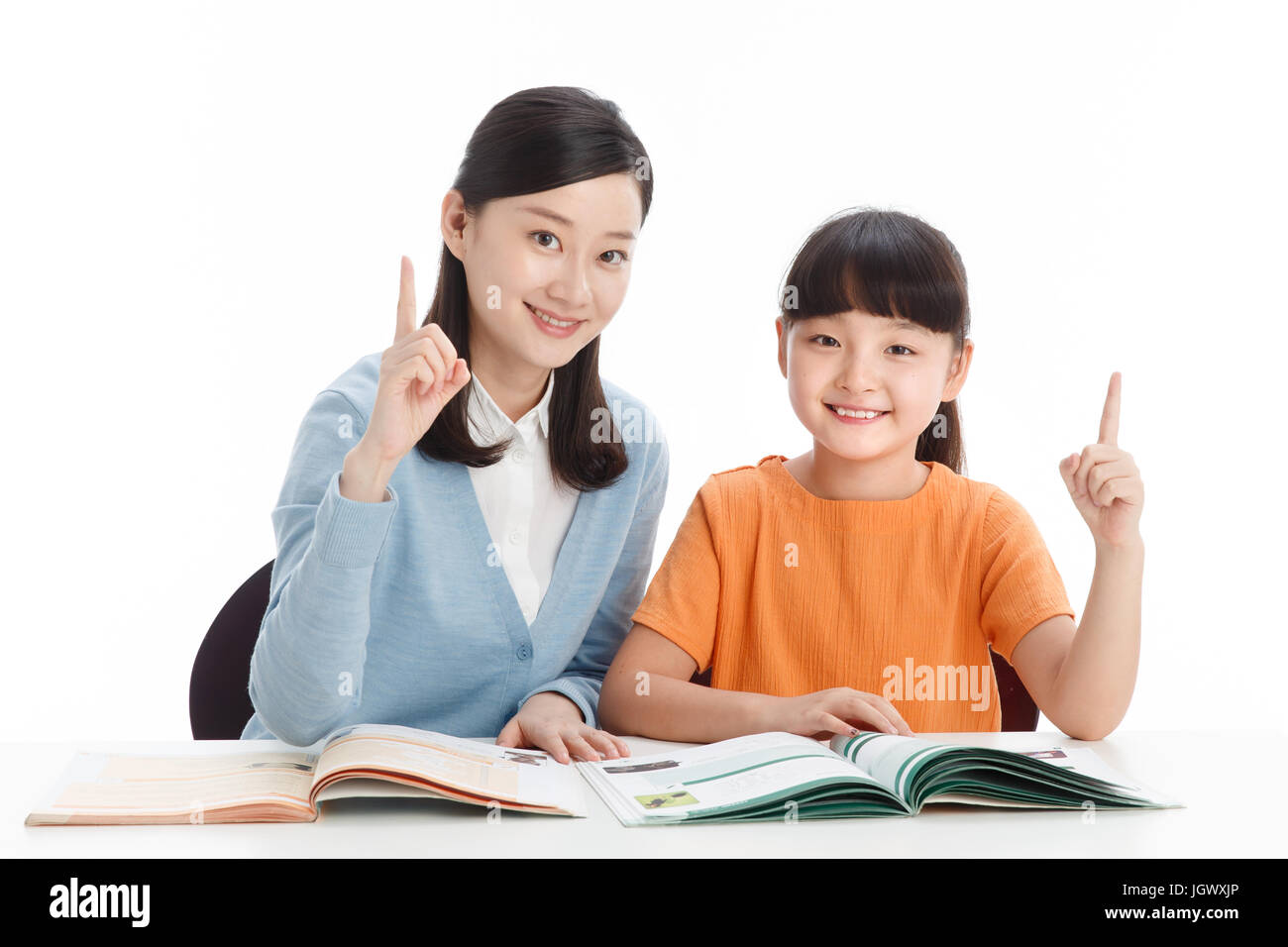 Female teacher helping school girl study Stock Photo - Alamy