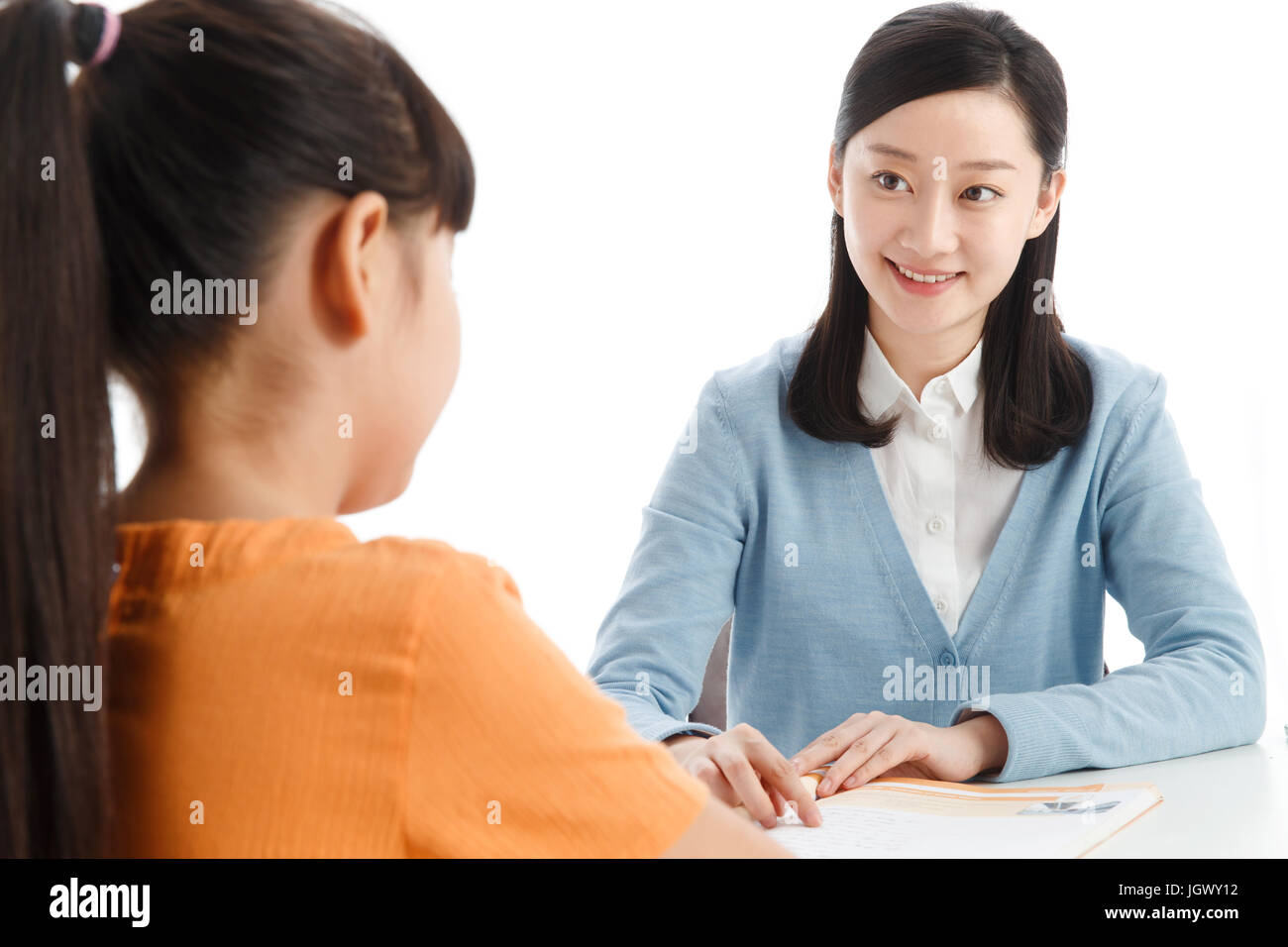 Female teacher helping school girl study Stock Photo - Alamy