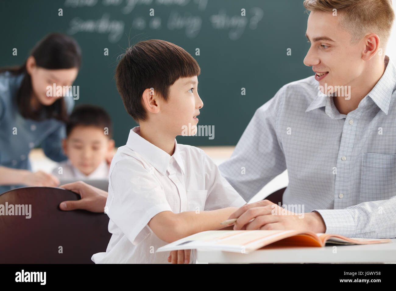 Male teacher helping student study Stock Photo - Alamy