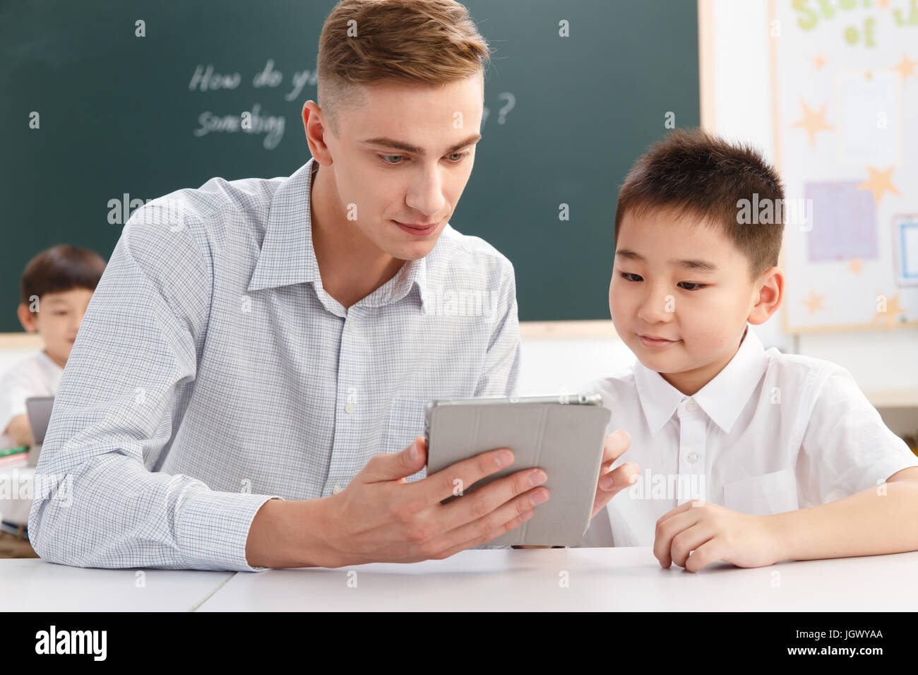 Male teacher helping student study Stock Photo - Alamy