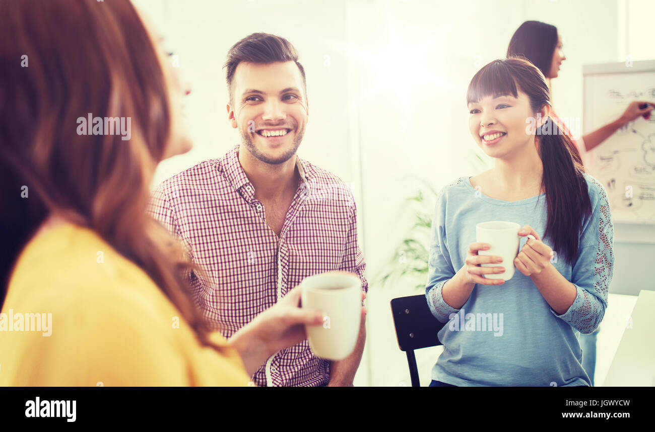 happy creative team drinking coffee at office Stock Photo - Alamy