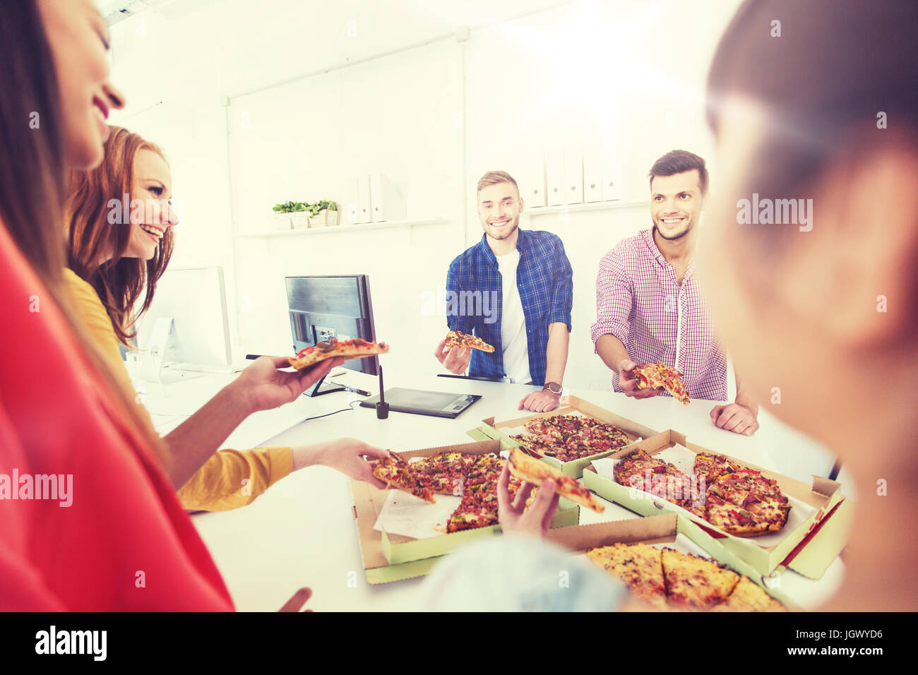 happy business team eating pizza in office Stock Photo - Alamy