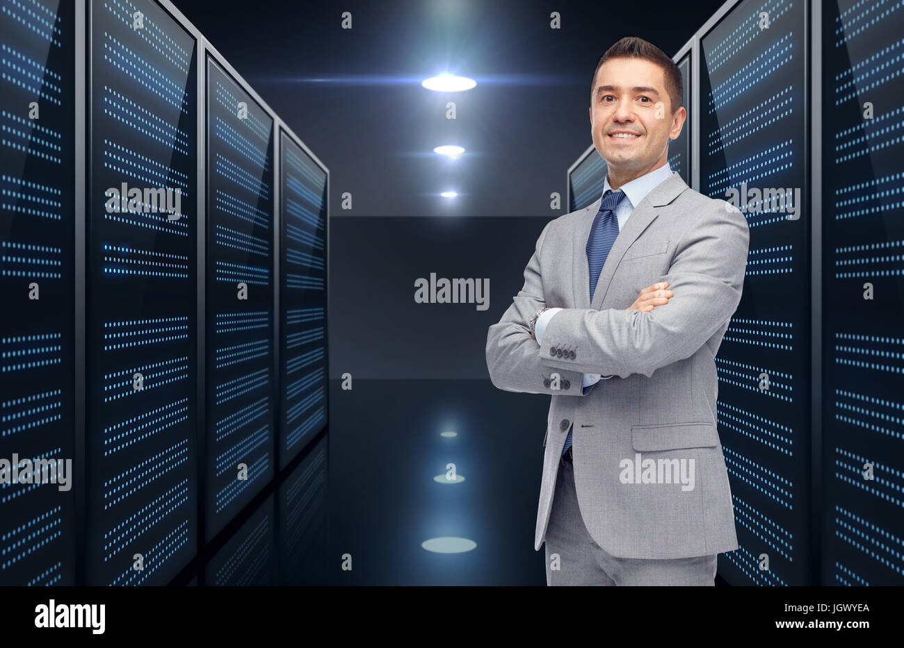 smiling businessman over server room background Stock Photo - Alamy
