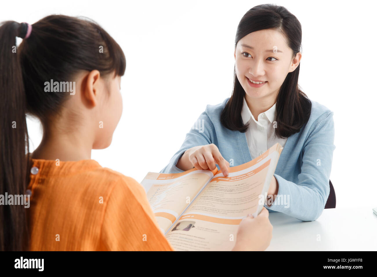 Female teacher helping school girl study Stock Photo - Alamy