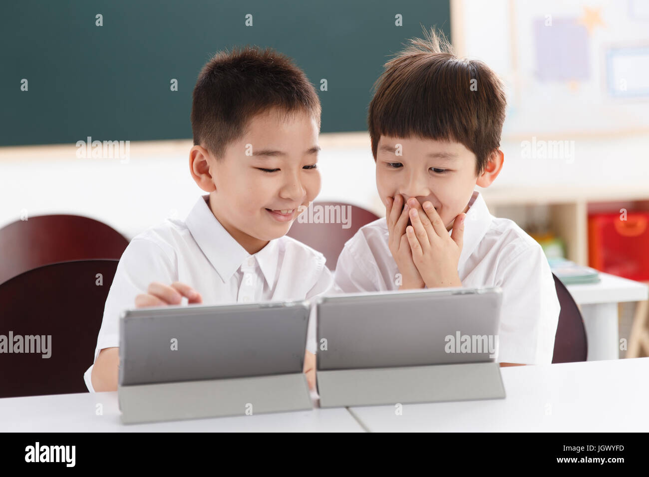 Two students using digital tablet in classroom Stock Photo - Alamy