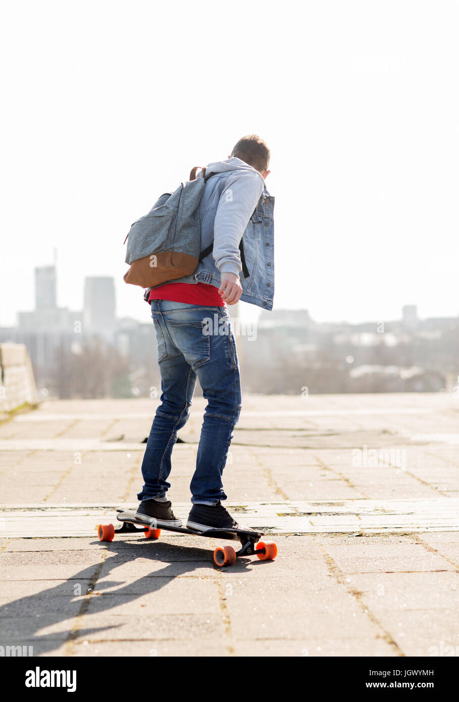 happy young man or teenage boy riding on longboard Stock Photo - Alamy