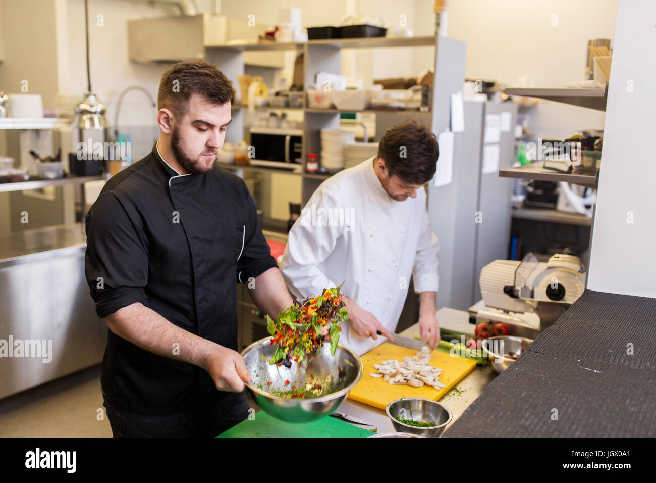 chef and cook cooking food at restaurant kitchen Stock Photo - Alamy