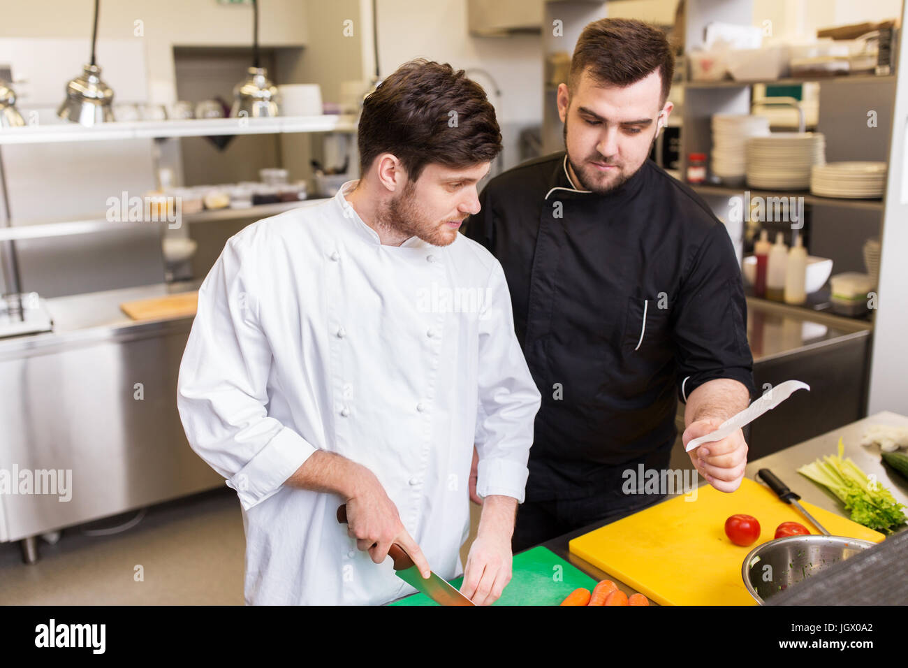 two chefs cooking food at restaurant kitchen Stock Photo - Alamy
