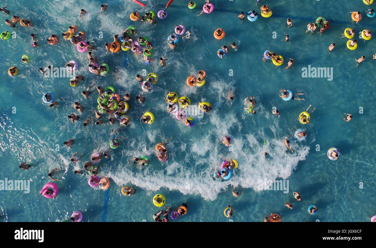 Yangzhou. 11th July, 2017. Tourists play in the water at a water park ...