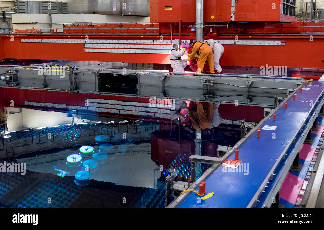 Workers in protective suits carry out inspection work over the opened ...