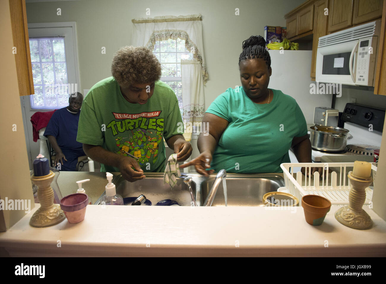 Athens, GA, USA. 13th Oct, 2014. Perry Hendricks washes dishes after dinner in his duplex ...