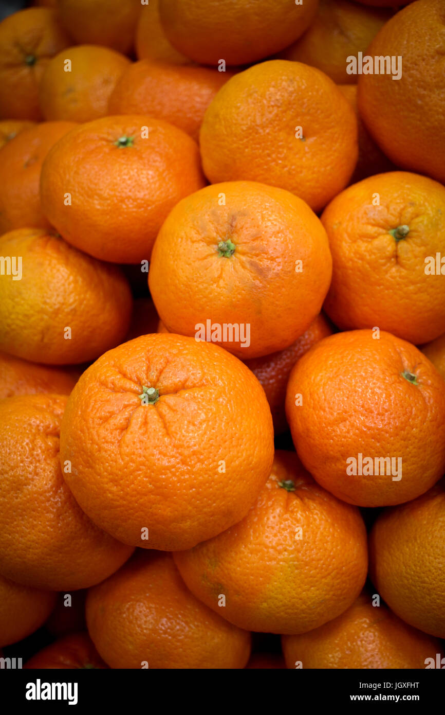 Close up of bright orange tangerines on display at a grocery store ...