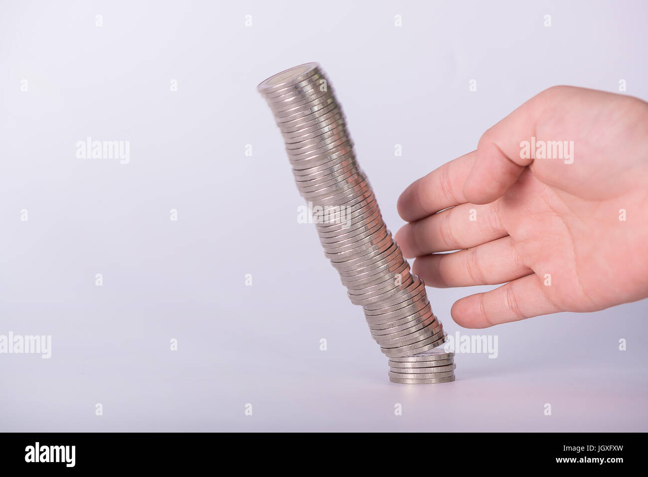Finger pushing a pile of coins, column of coins falls , business crisis ...