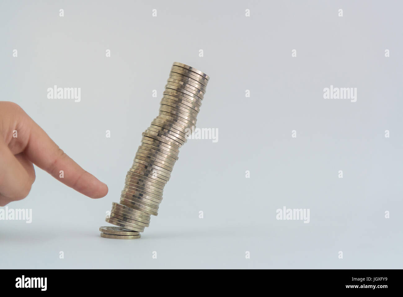 Finger pushing a pile of coins, column of coins falls , business crisis ...